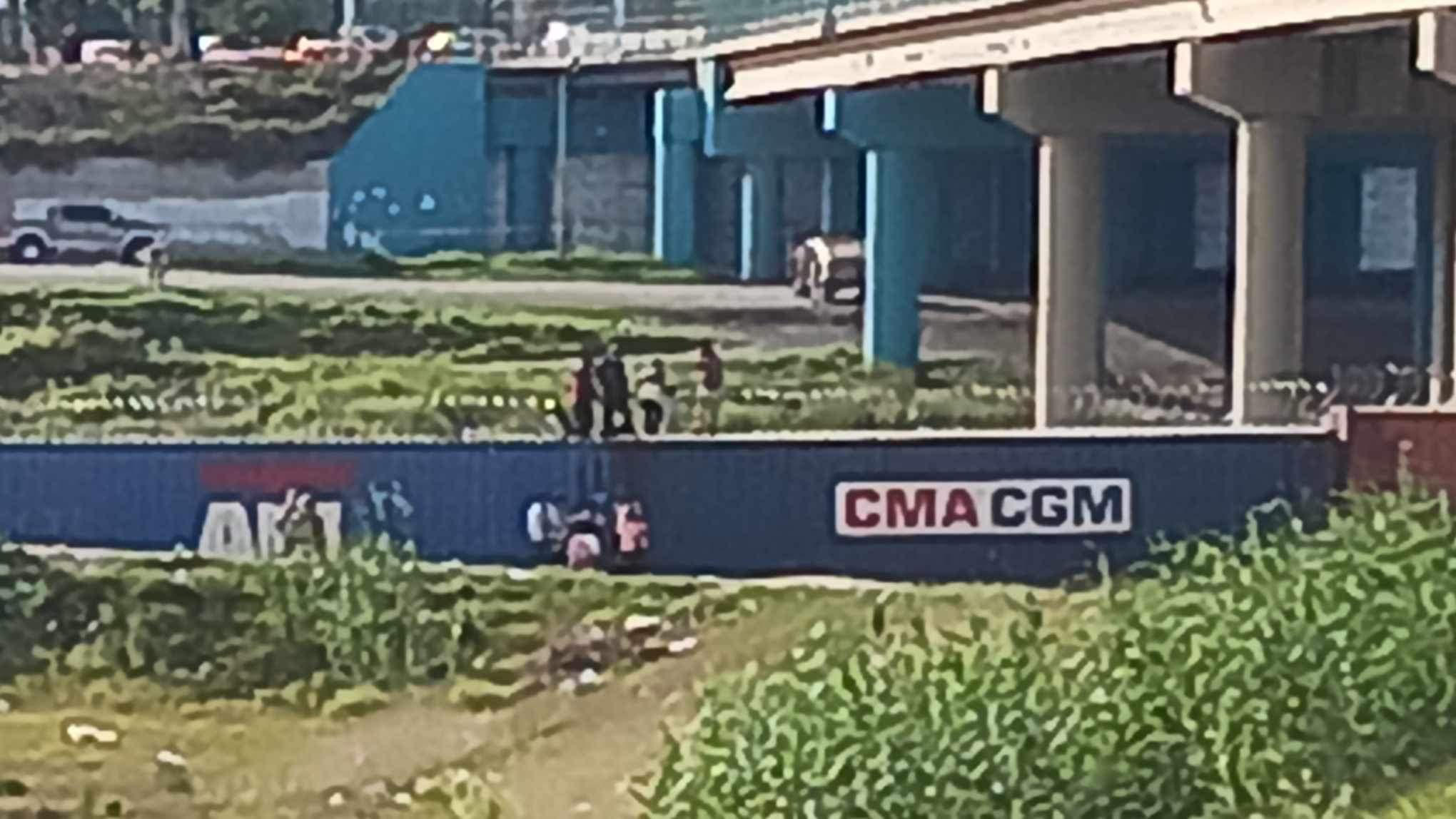 The Border: Undocumented migrants scale box car barriers using ladders ...